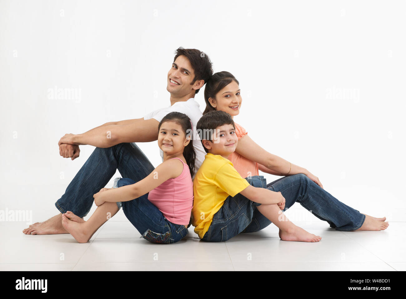 Portrait of a family sitting back to back Stock Photo - Alamy