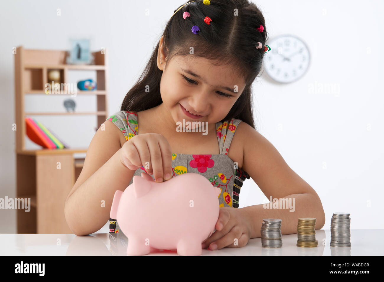 Indian girl holding piggy bank hi-res stock photography and images - Alamy