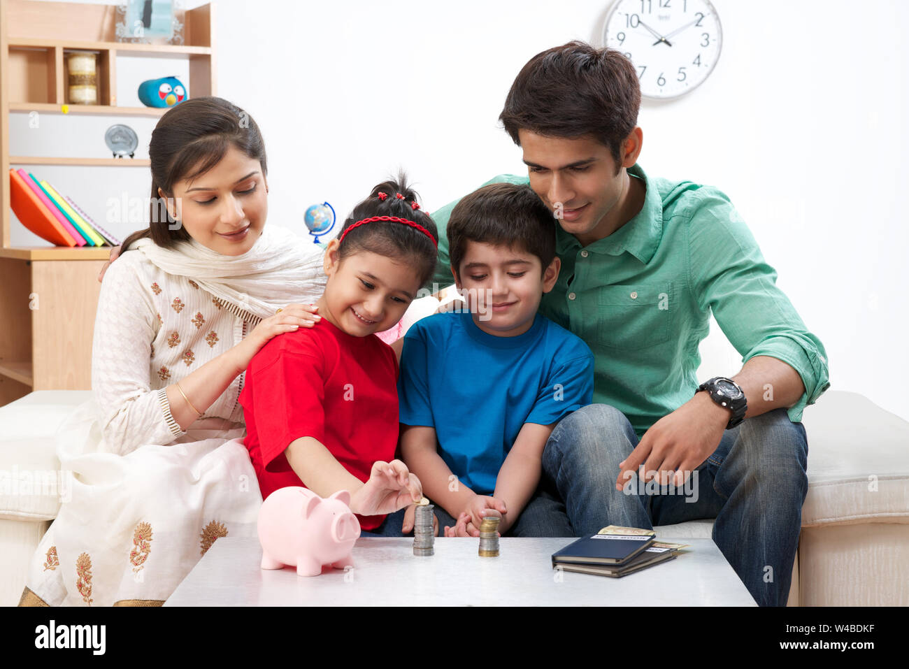Parents assisting their children to save money Stock Photo - Alamy