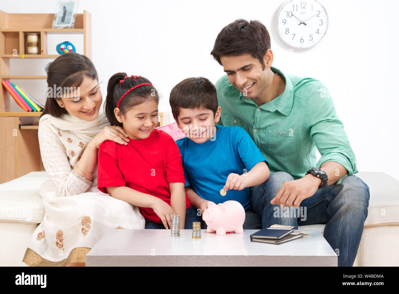 Parents assisting their children to save money Stock Photo - Alamy