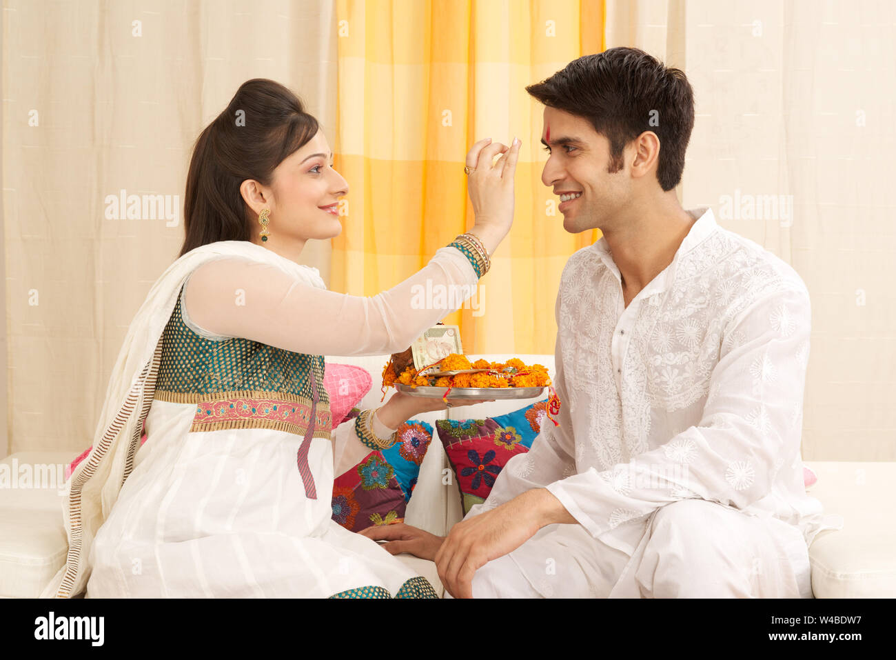 Woman applying tika on her brother forehead at Raksha Bandhan festival ...