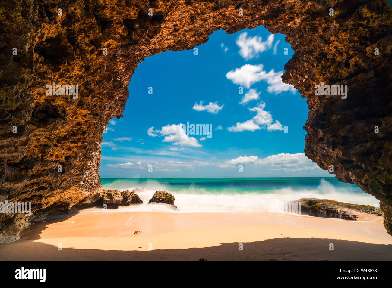 View on turquoise sea through a stone cave in Bali, Indonesia Stock ...