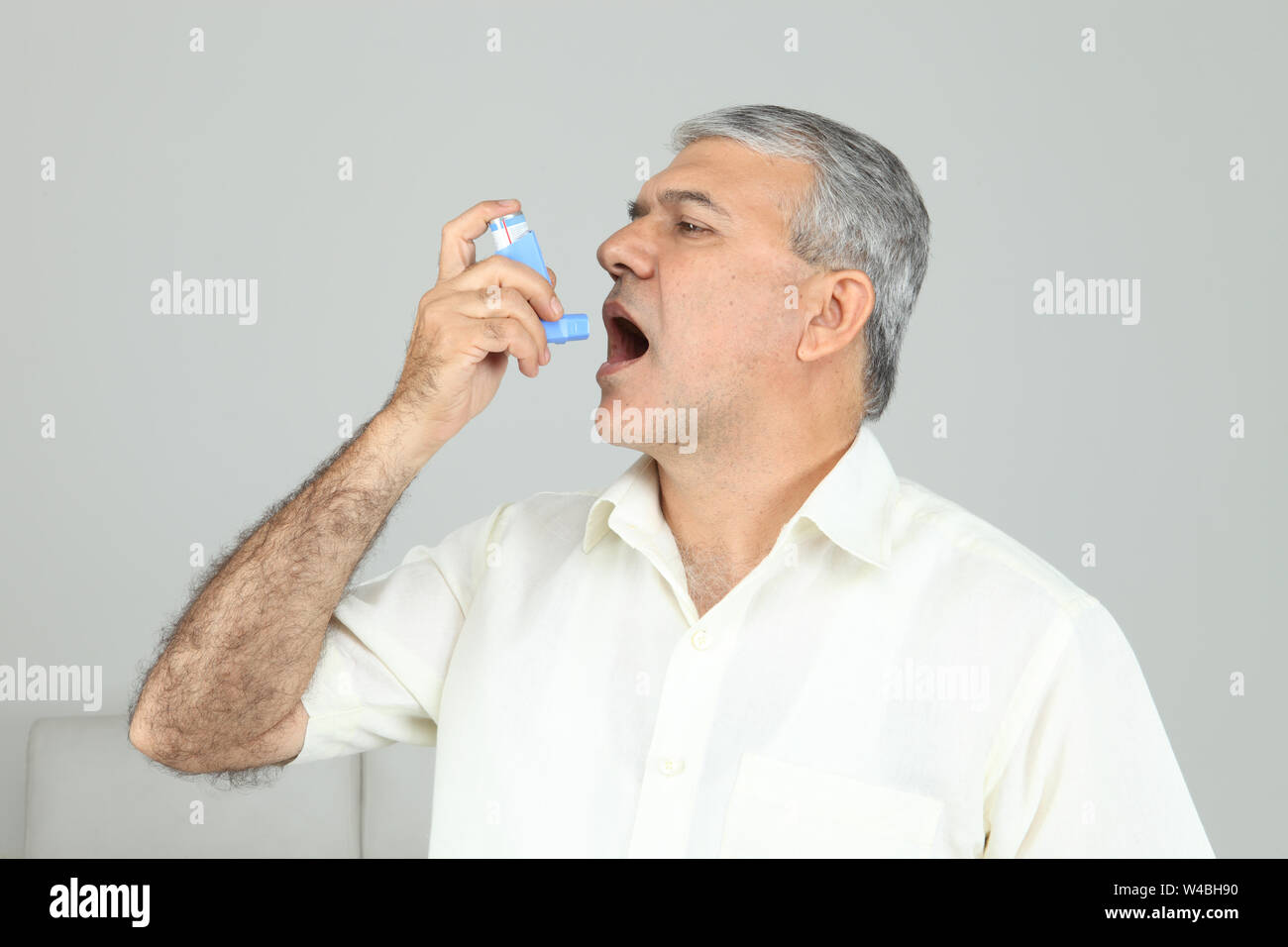 Old man using asthma inhaler Stock Photo - Alamy
