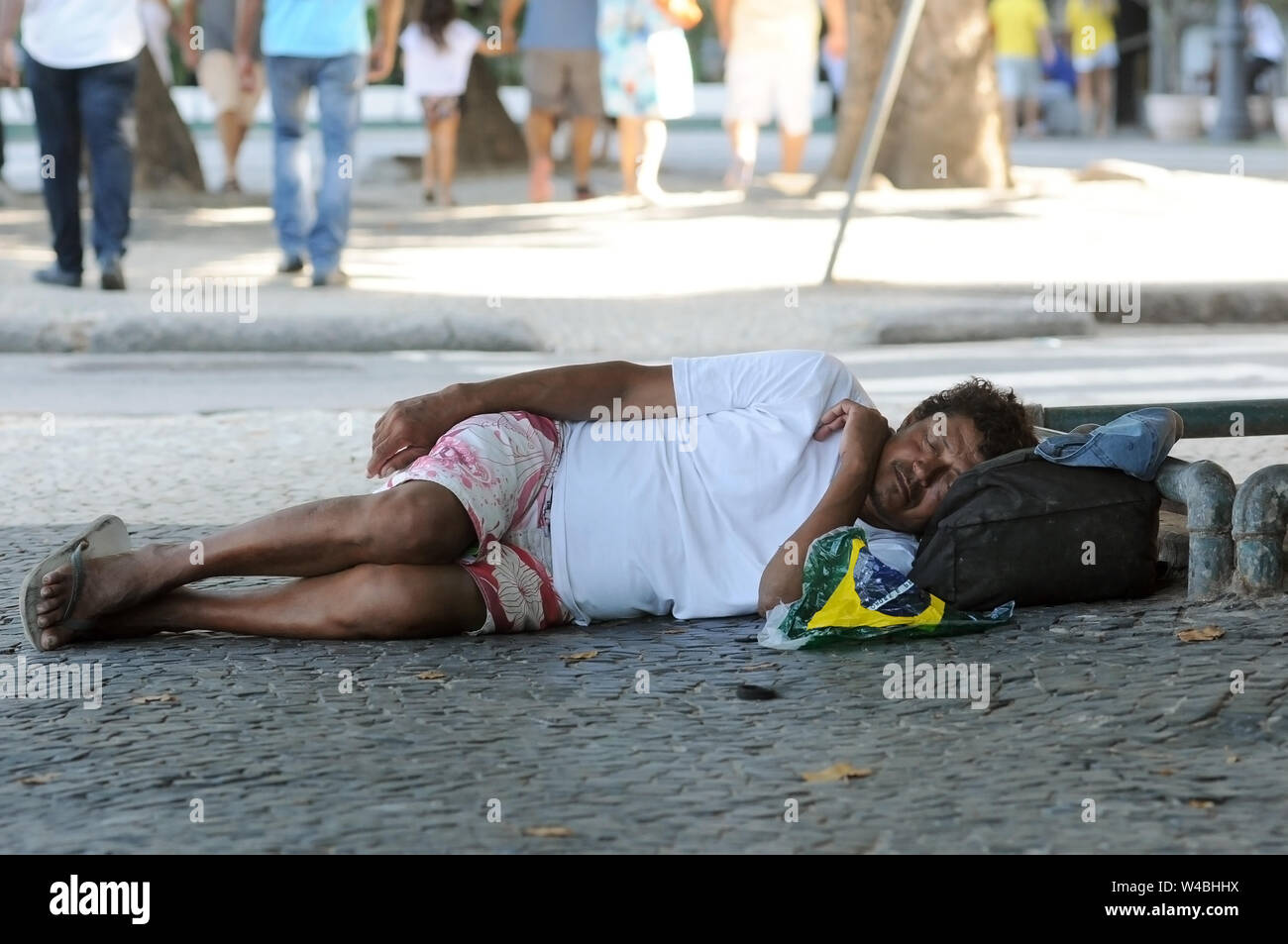 Street dweller sleeping on the sidewalk of Avenida Atlântica in the ...