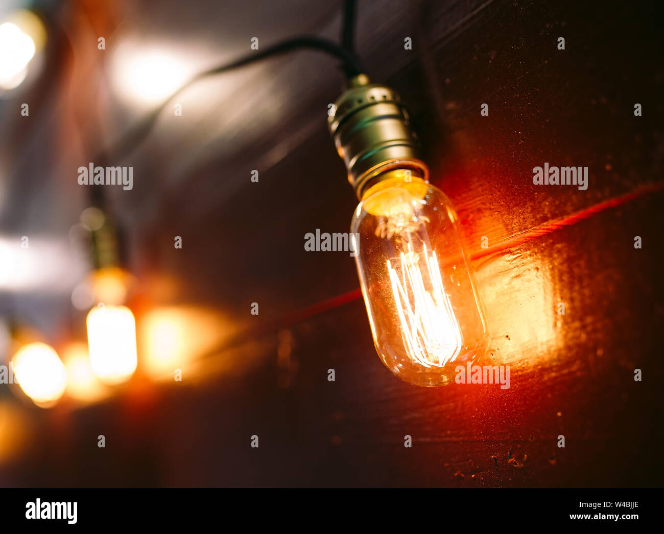 Vintage incandescent Edison type bulbs on wooden wall Stock Photo - Alamy