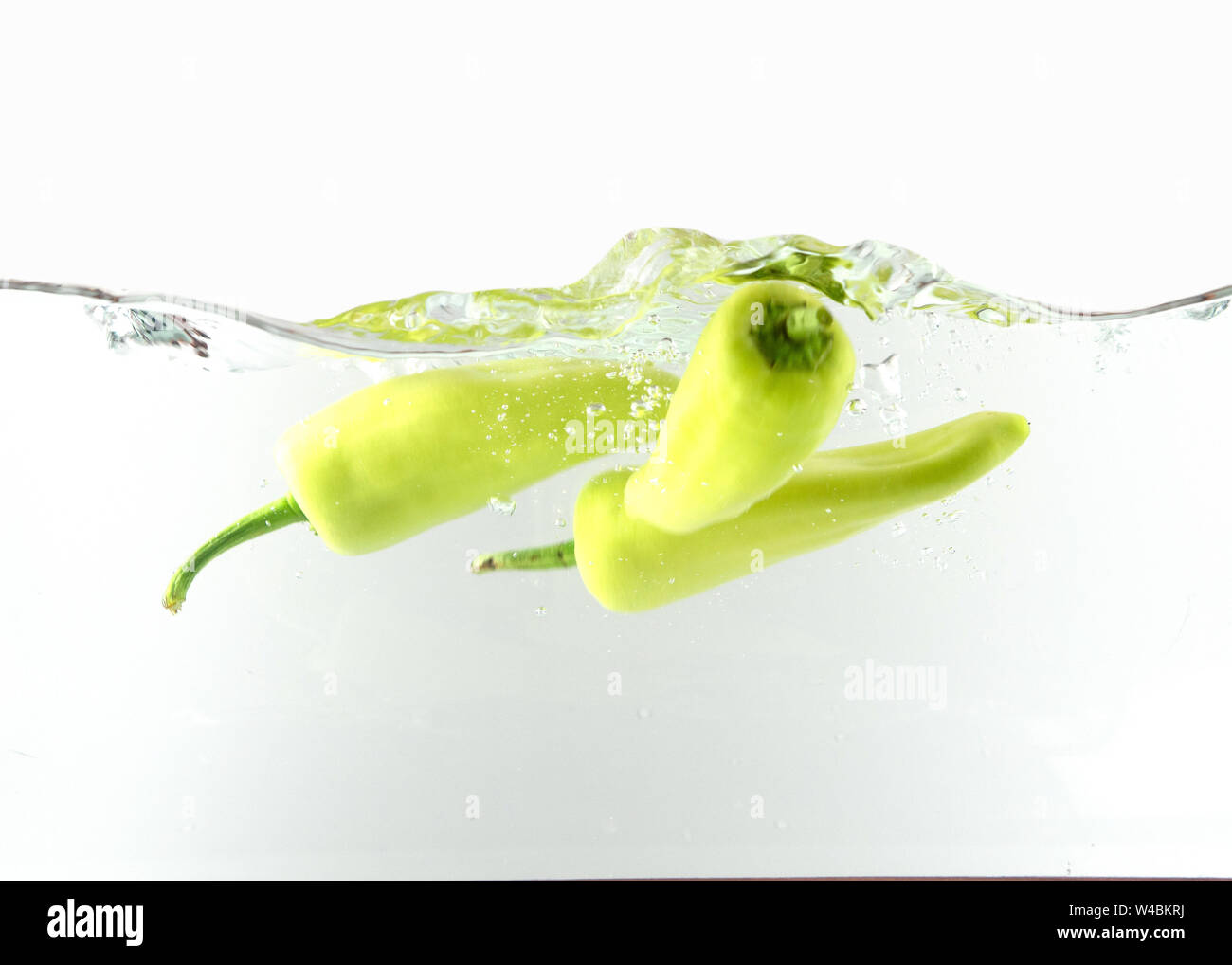 Green chili in water isolated on a white background Stock Photo - Alamy