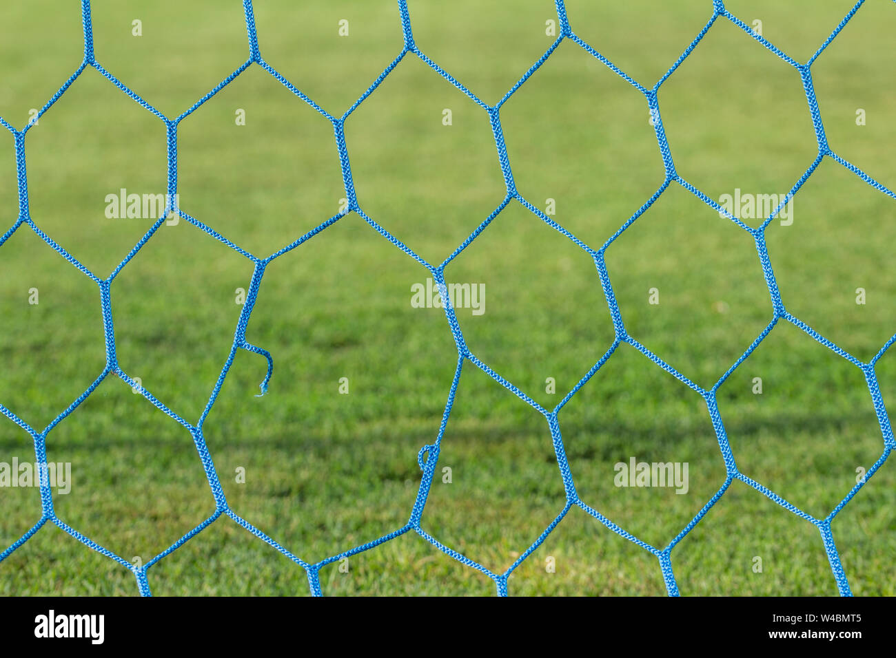 Torn football goal net close up. Old torn net on the football goal ...