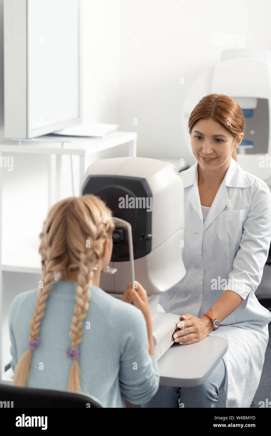 In private clinic. Blonde-haired girl visiting eye doctor in private ...