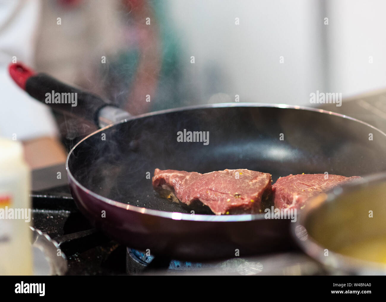 Fry the meat in a frying pan. Chef preparing and spicing meat ...