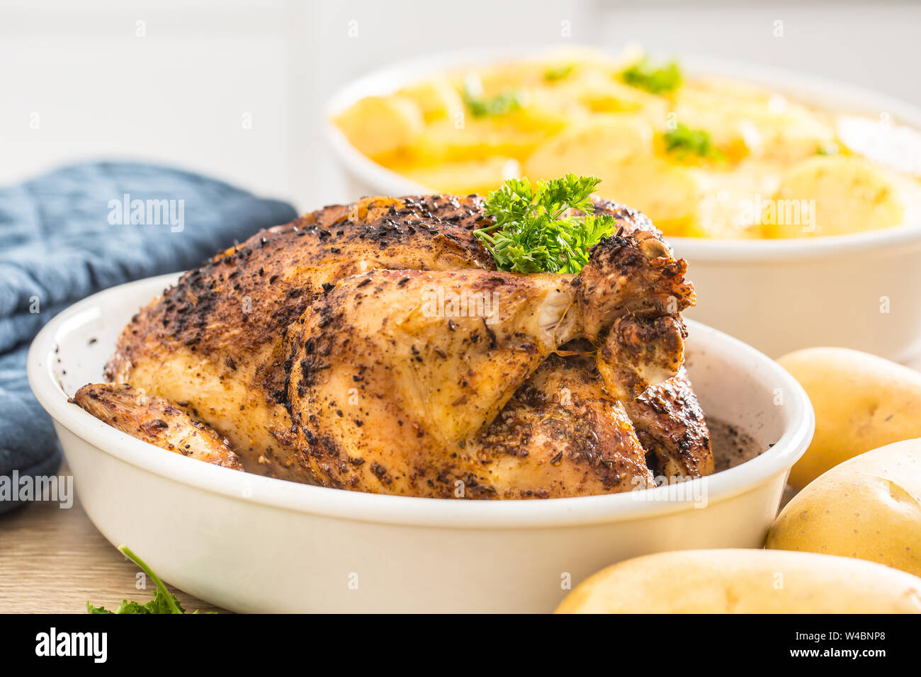 Whole chicken roasted in a porcelain bowl with potatoes Stock Photo - Alamy