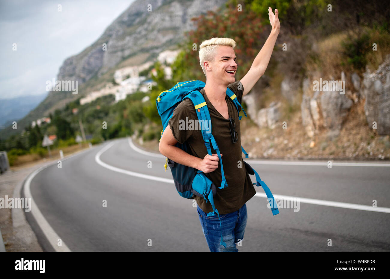 Travel man backpacking hitchhiking on road trip hitching a ride from ...