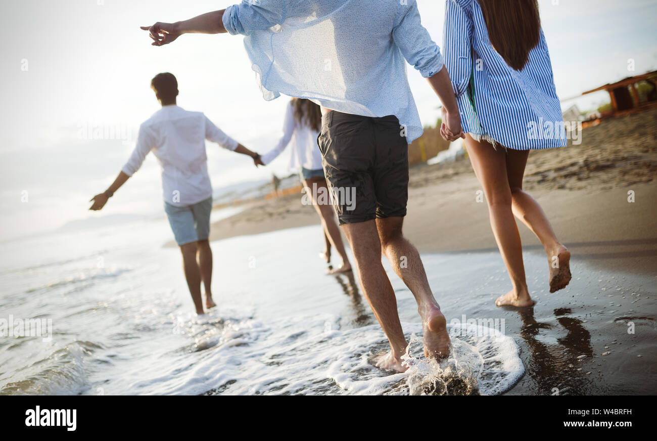 Friends having fun on the beach under sunset sunlight Stock Photo - Alamy
