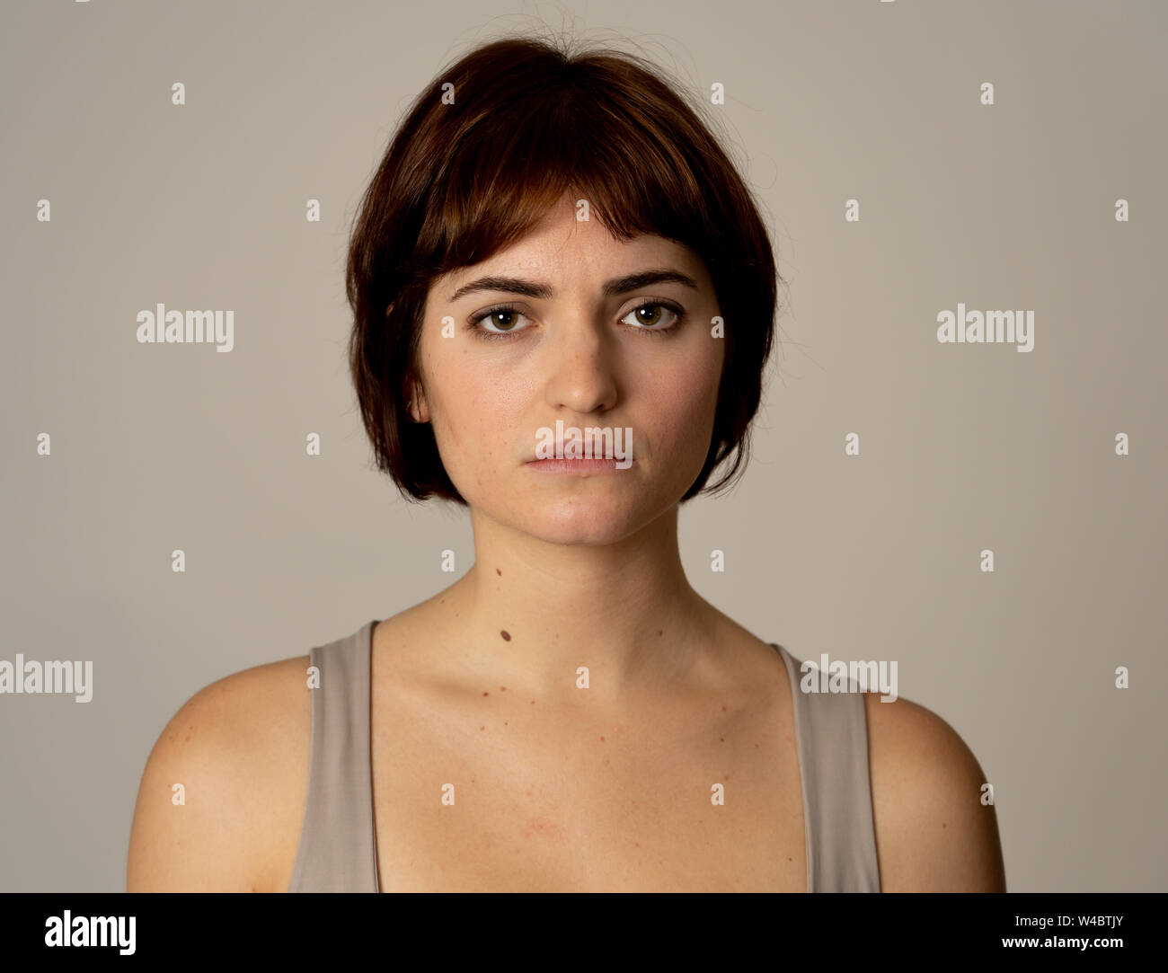 Close up of a young sad woman, serious and concerned, looking worried ...