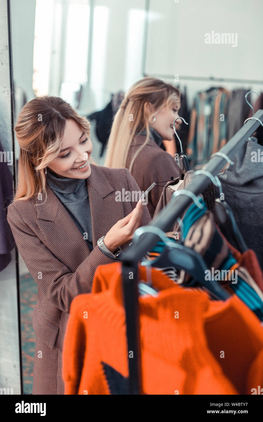Appealing woman smiling after finding amazing dress Stock Photo - Alamy