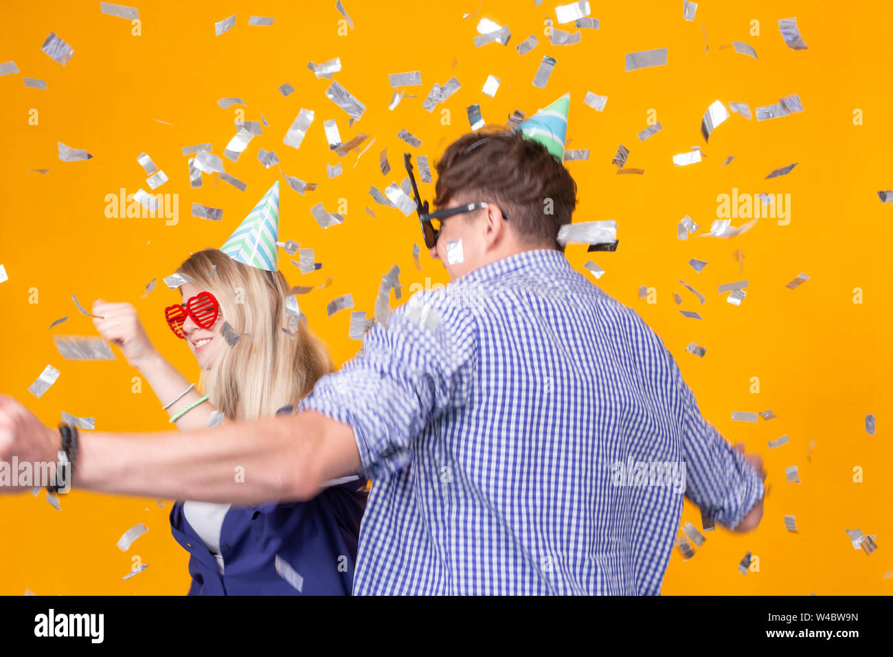 Fun, holidays and party concept - Couple dancing among falling confetti ...