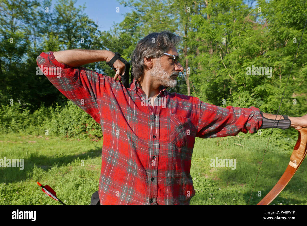 side view of an archer after releasing his arrow Stock Photo - Alamy