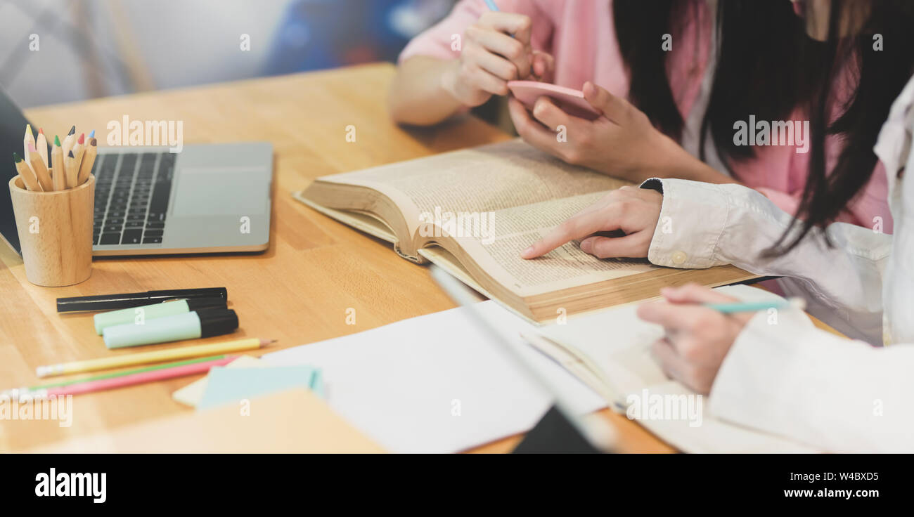 Cheerful young female student helps friend catching up and learning ...