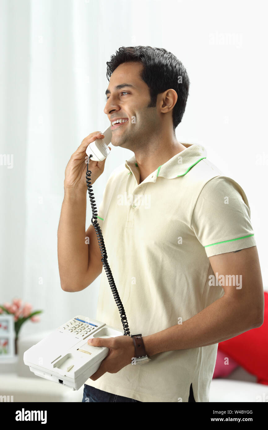 Man talking on a landline phone and smiling Stock Photo - Alamy