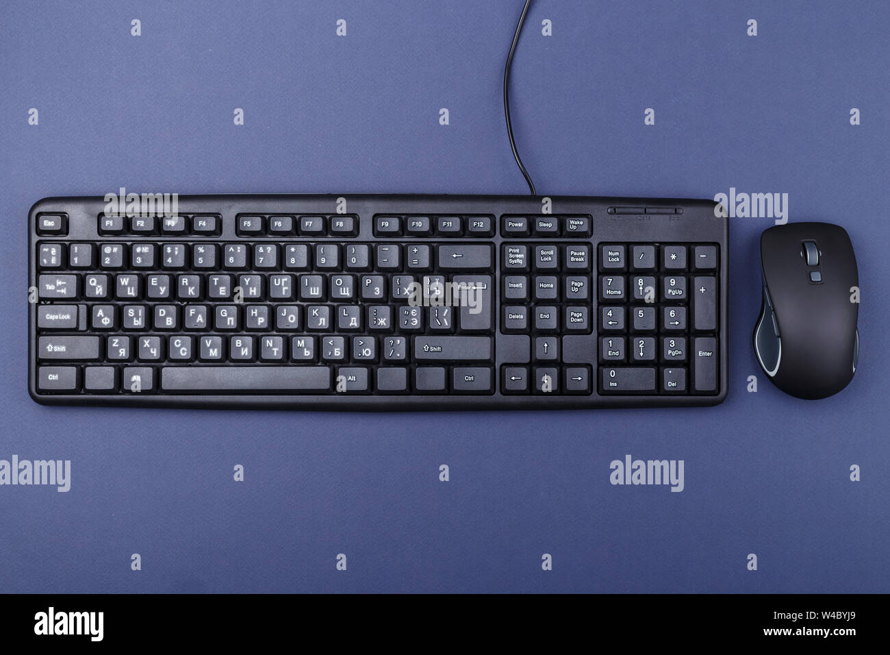 computer keyboard with mouse on a blue background. view from above ...