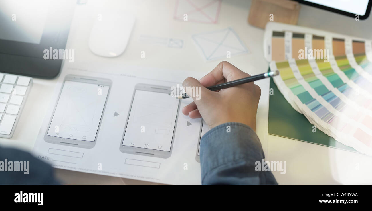 Close-up of UI UX graphic designer drawing smartphone template for his ...