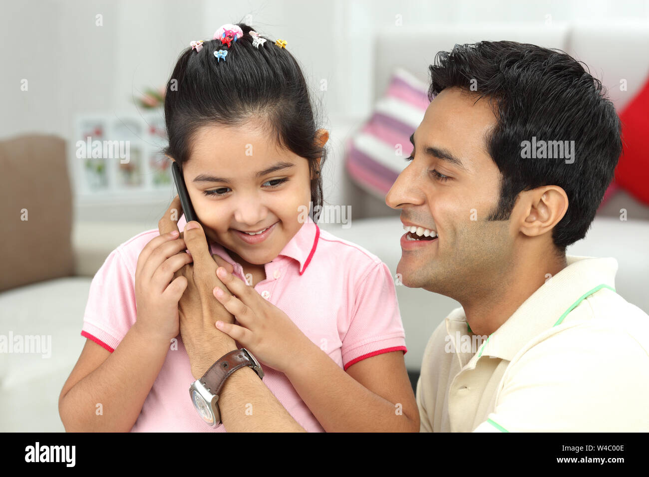 Girl with her father talking on a mobile phone Stock Photo - Alamy