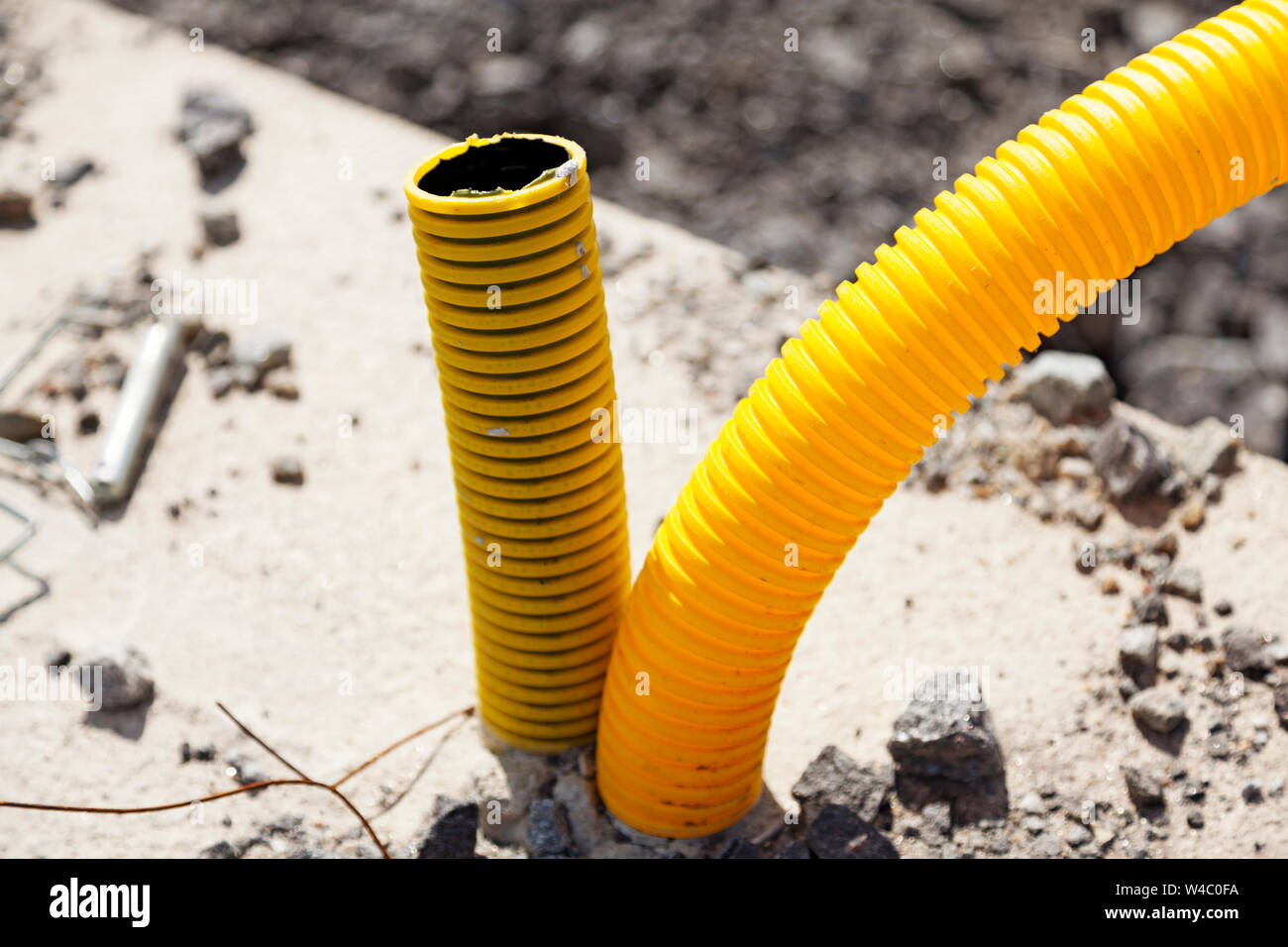 two yellow plastic pipes come up from the ground Stock Photo - Alamy