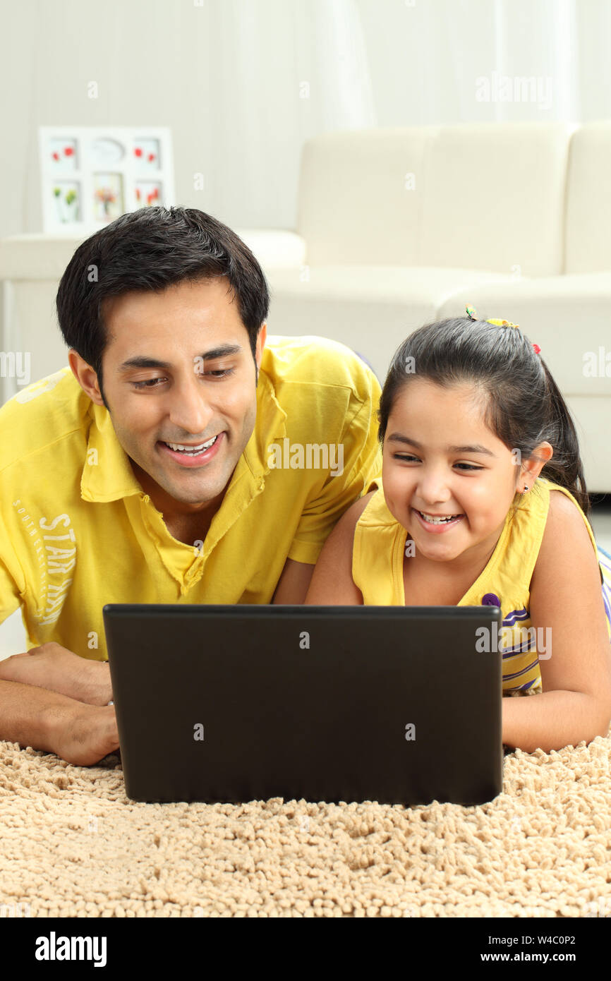 Man assisting his daughter in using laptop Stock Photo - Alamy