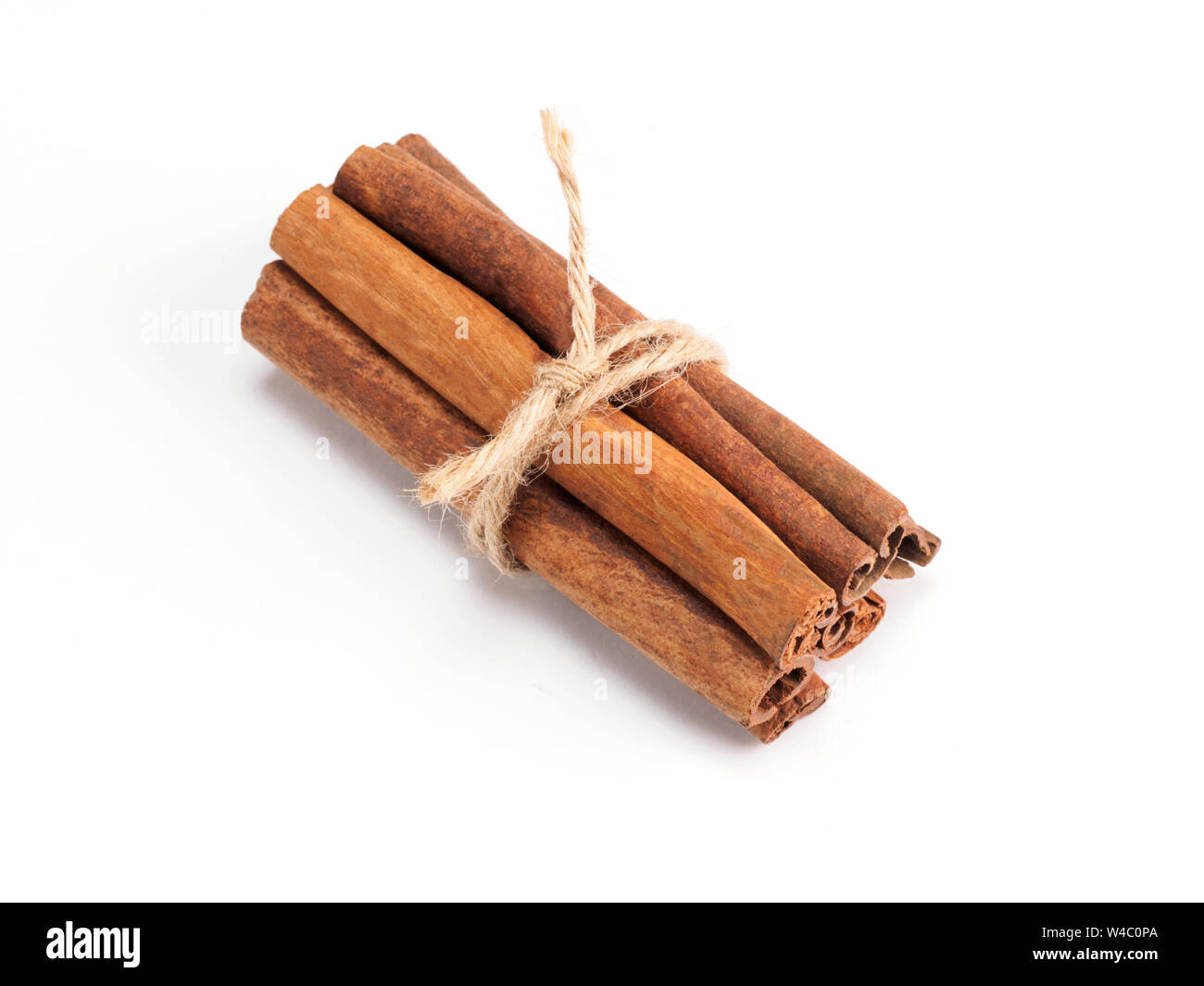 Spice cinnamon wrapped with rope on a white background Stock Photo - Alamy