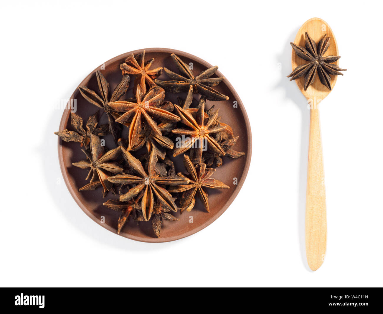 Anise (Anisum vulgare) on a brown clay plate on a white background with ...