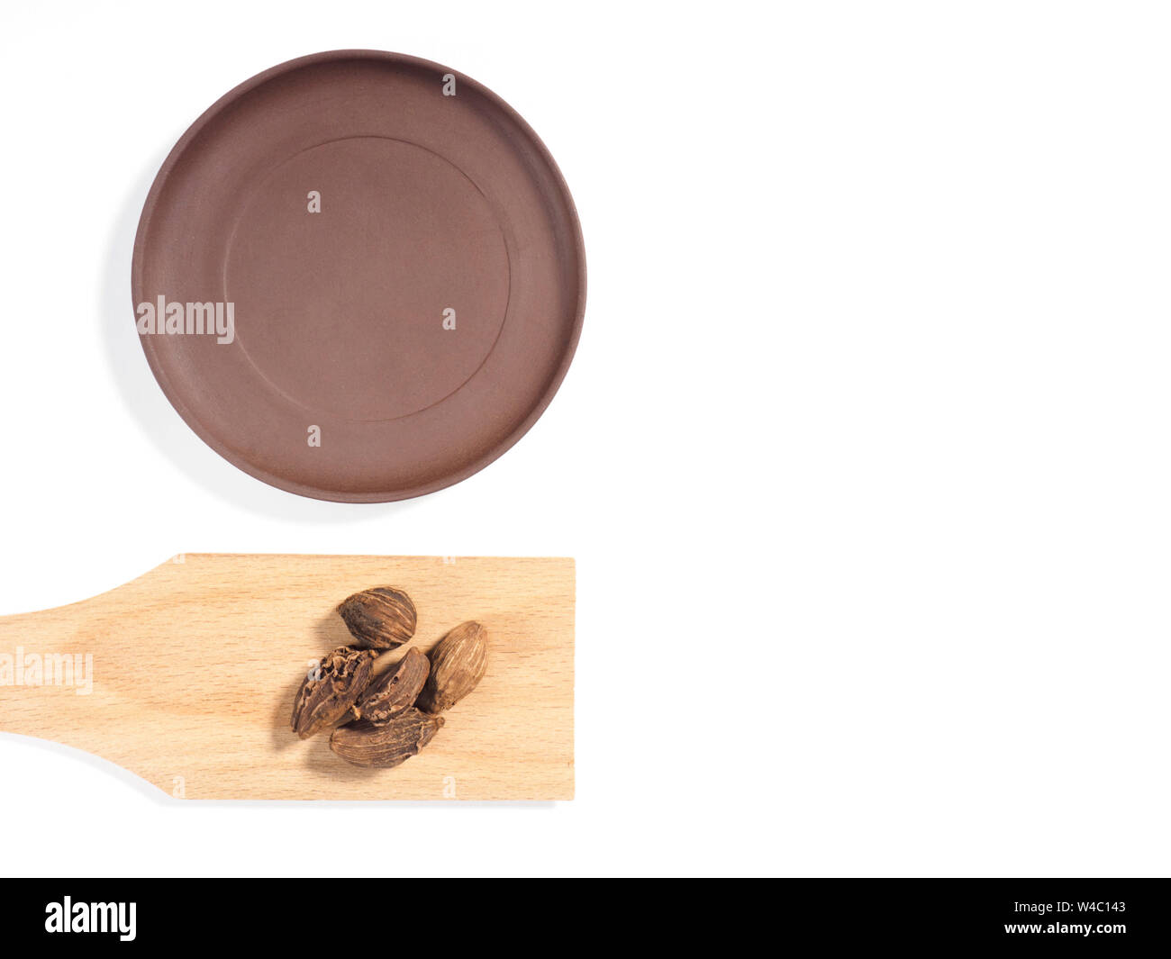 Black cardamom (Amomum subulatum) on spoon on a white background with ...