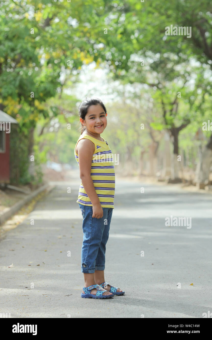 Girl standing on road and smiling Stock Photo - Alamy
