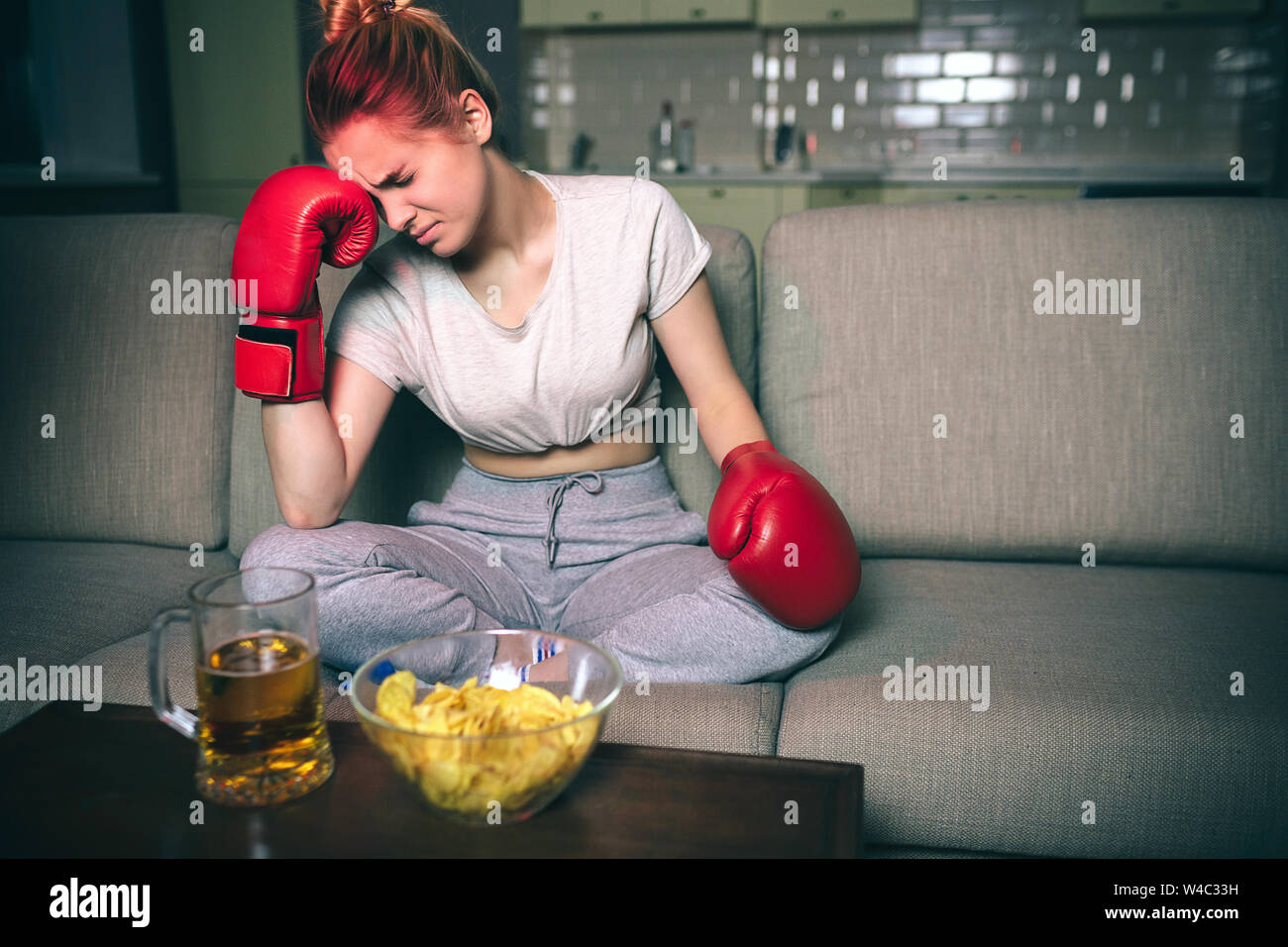 Young woman watch boxing on tv at night. Upset unhappy model sit on ...