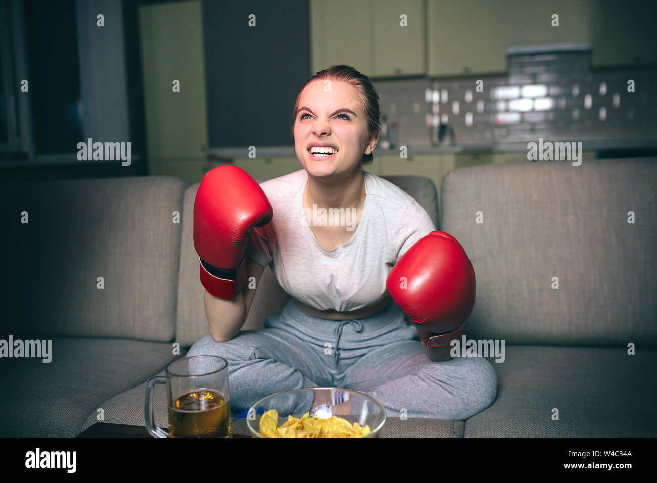 Young woman watch boxing on tv at night. Emotional angry model look up ...