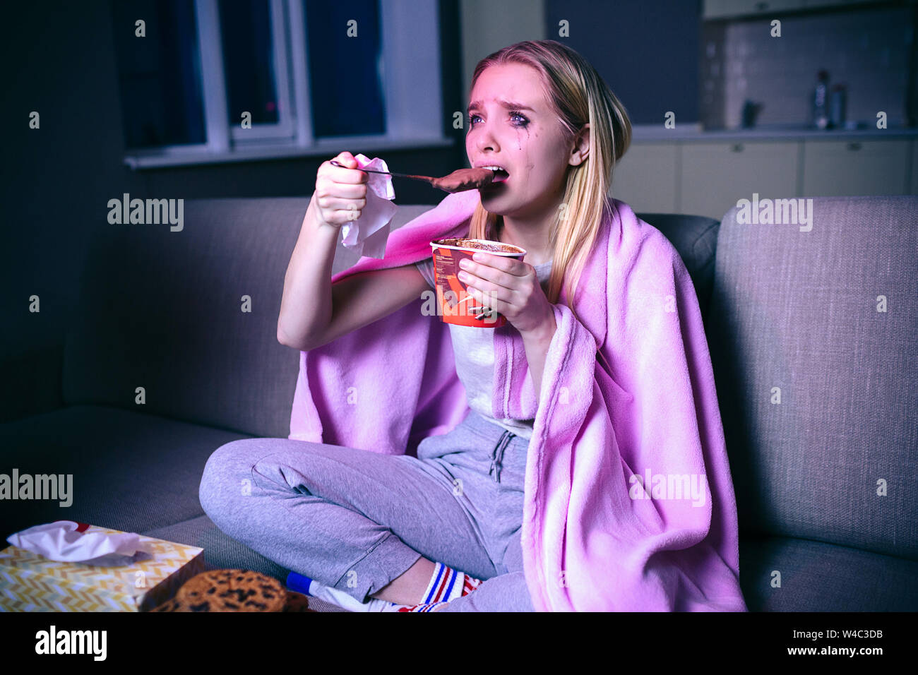 Young woman watching movie at night. Sad picture of model sitting on ...