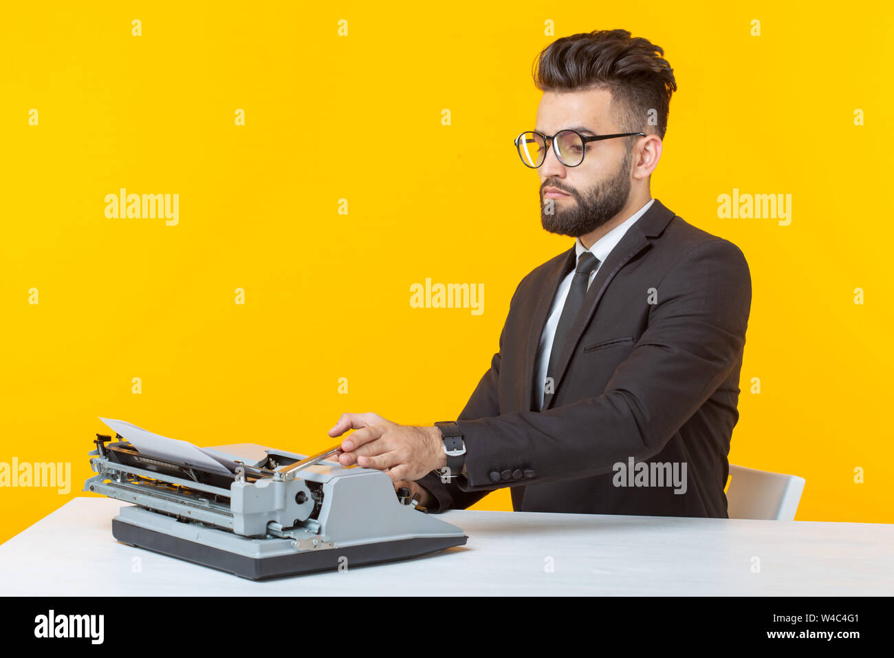 Young handsome male businessman in formal clothes typing text on a ...