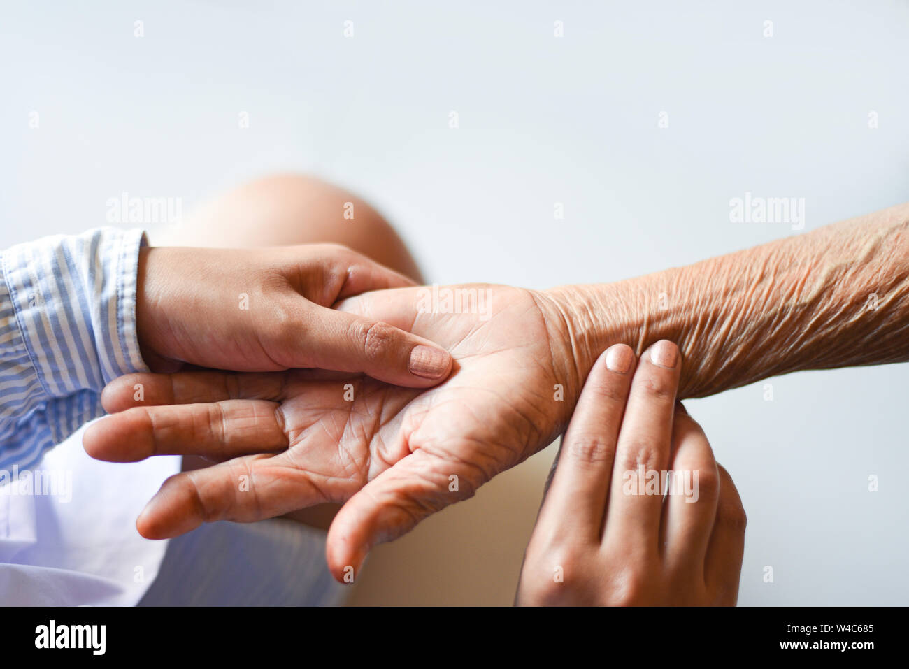 Senior patient and nurse / Pulse measurement by hand check the heart ...