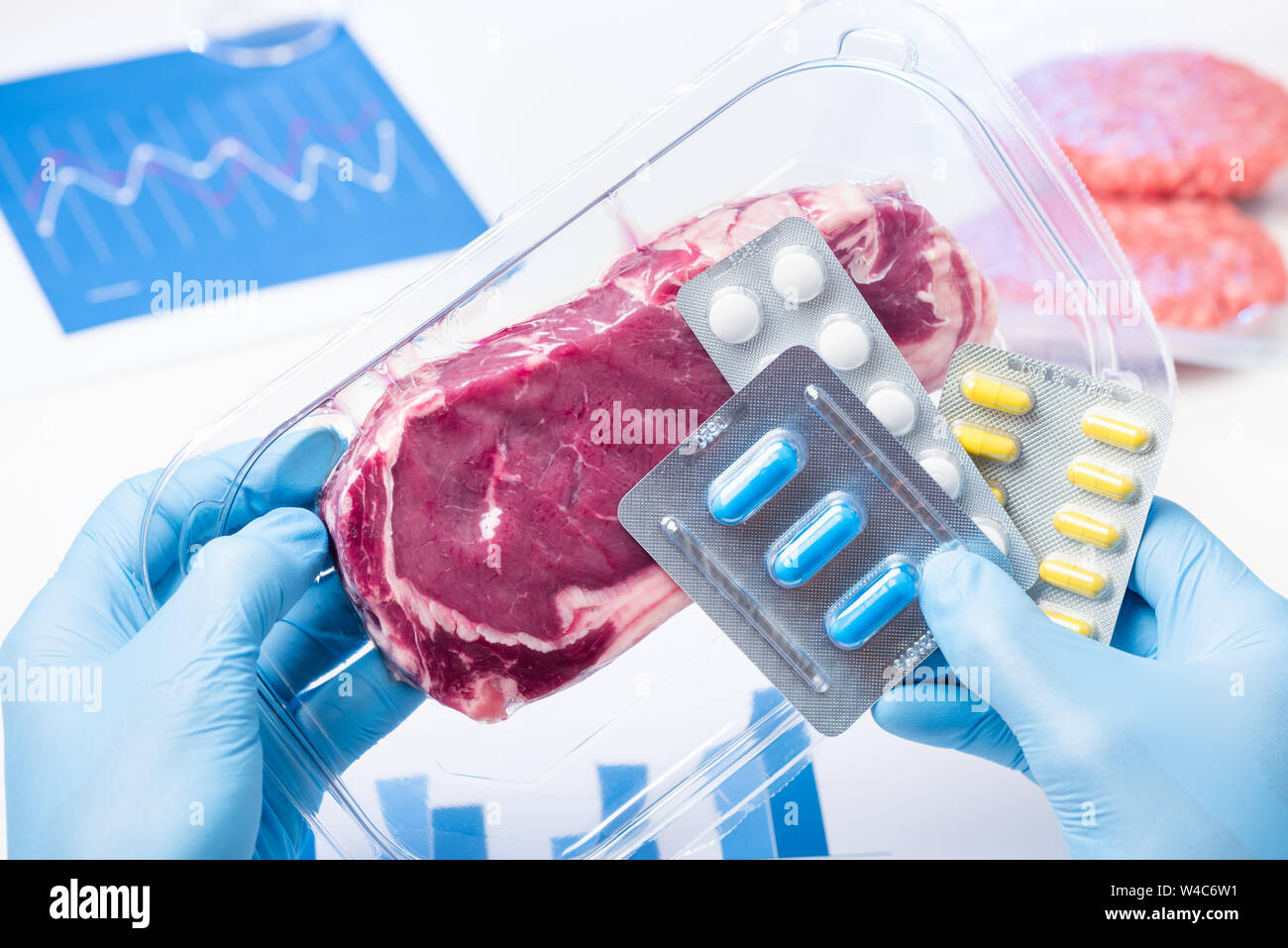 Packaged meat and drugs pills in laboratory scientist hands. Livestock ...