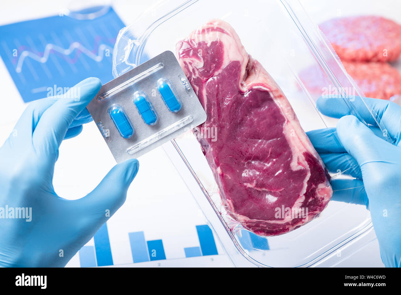 Vacuum packaged meat and drugs pills pack in laboratory scientist hands ...