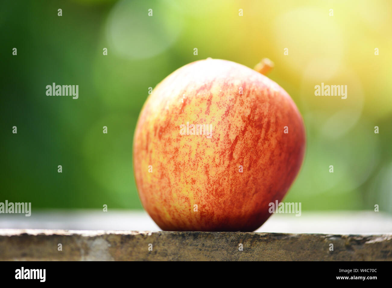 Fresh red apple on wooden table and nature green background in the ...