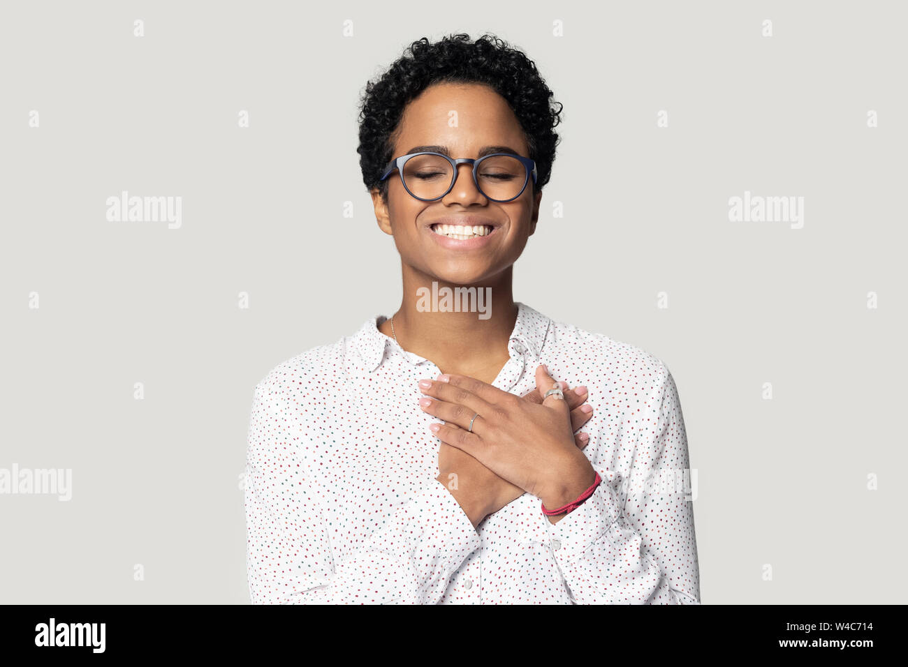 Smiling biracial woman with hands at chest feel thankful Stock Photo ...