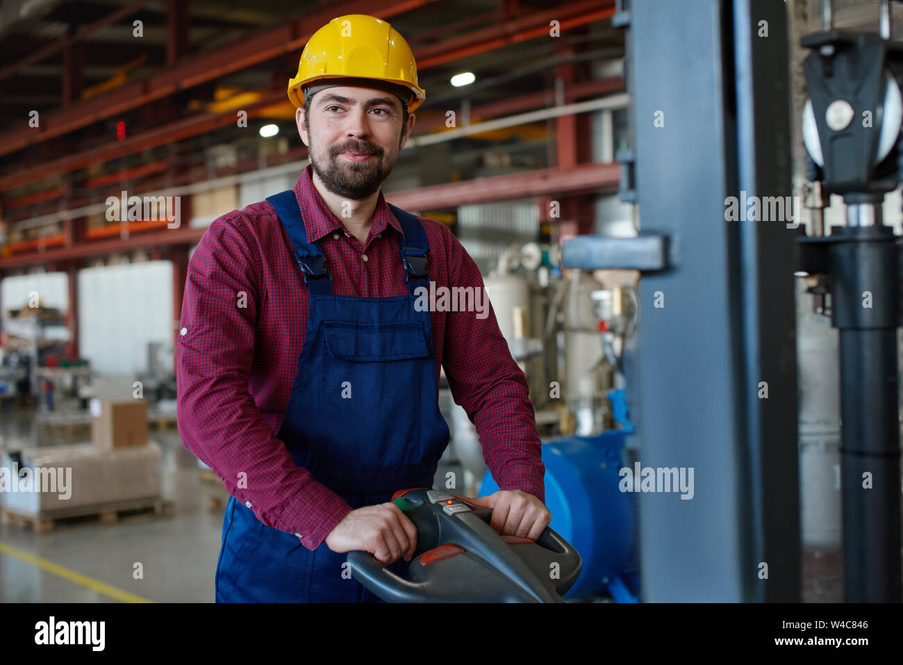 Engineer in hard hat working with mechanical equipment at the ...