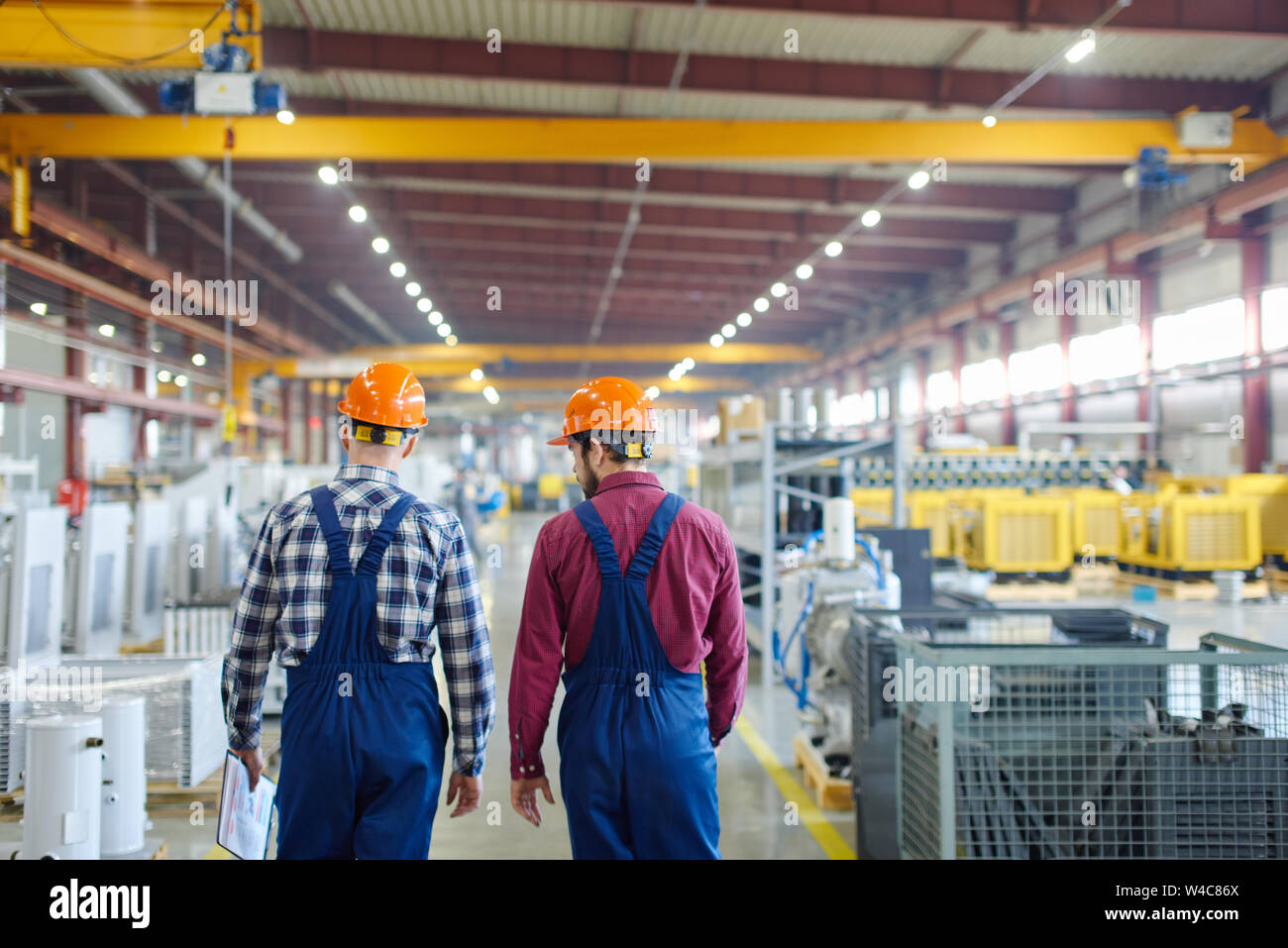 Engineers walking along the plant they work at shot from the back Stock ...
