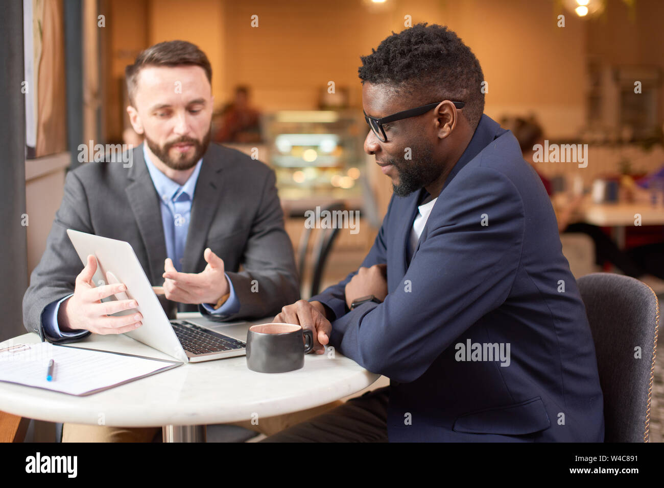 Two businessmen having a look at the computer screen Stock Photo - Alamy