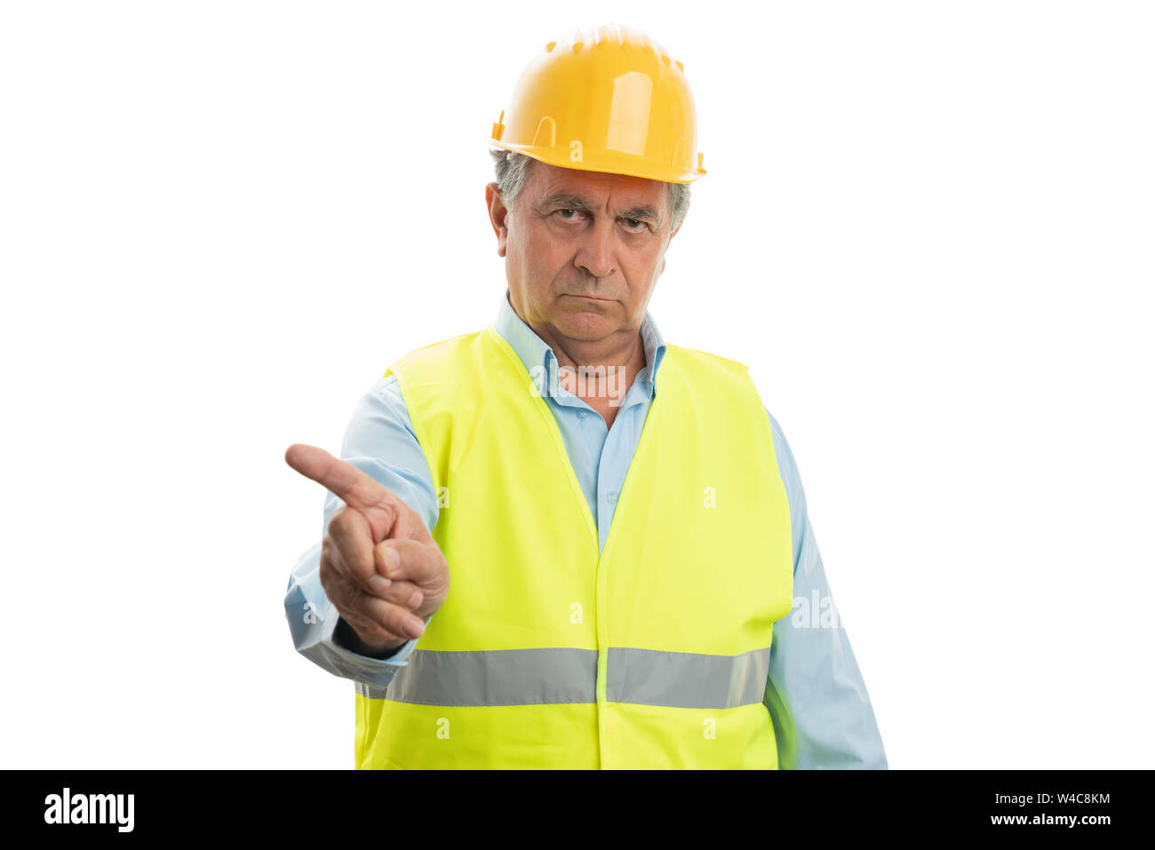 Old builder man with serious expression pointing at blank copyspace ...