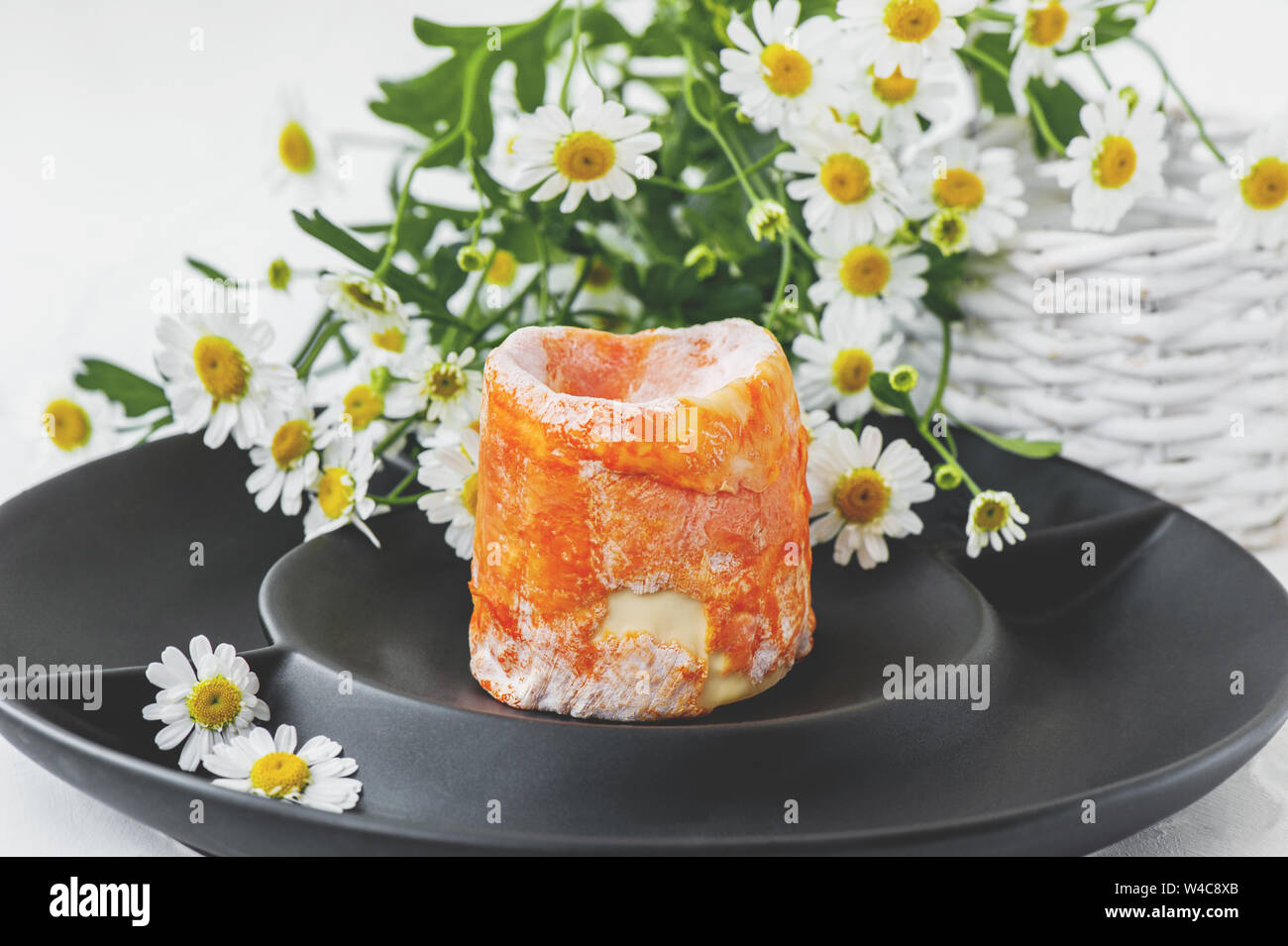 French soft cheese with white mold orange rind epoisses on a black ...