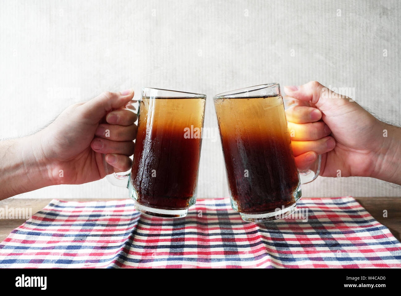 Close-up two hands are clinking glasses of cold drink Stock Photo - Alamy