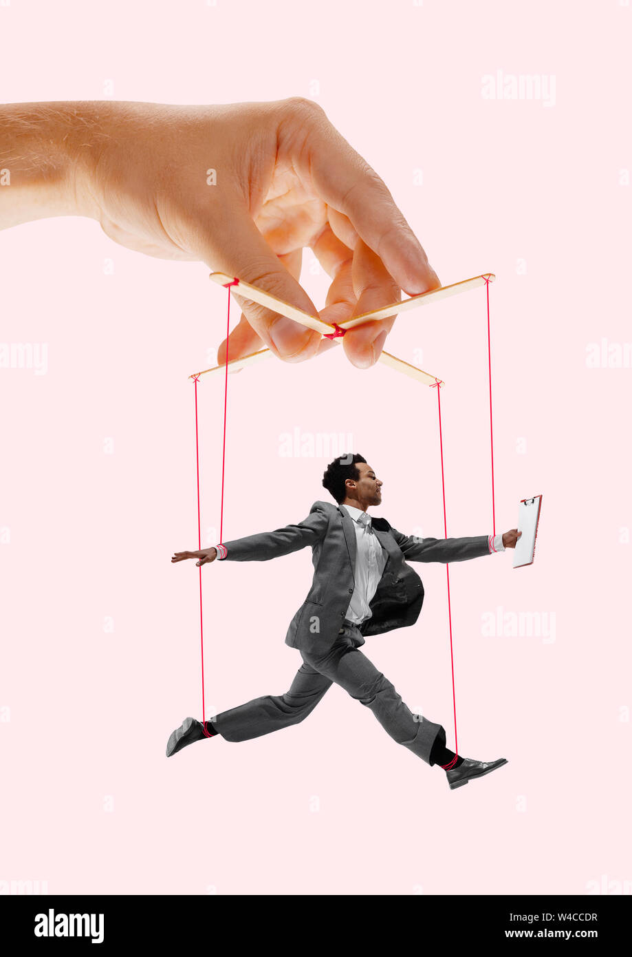 Man like a puppet in somebodies hands on coral background. Concept of ...