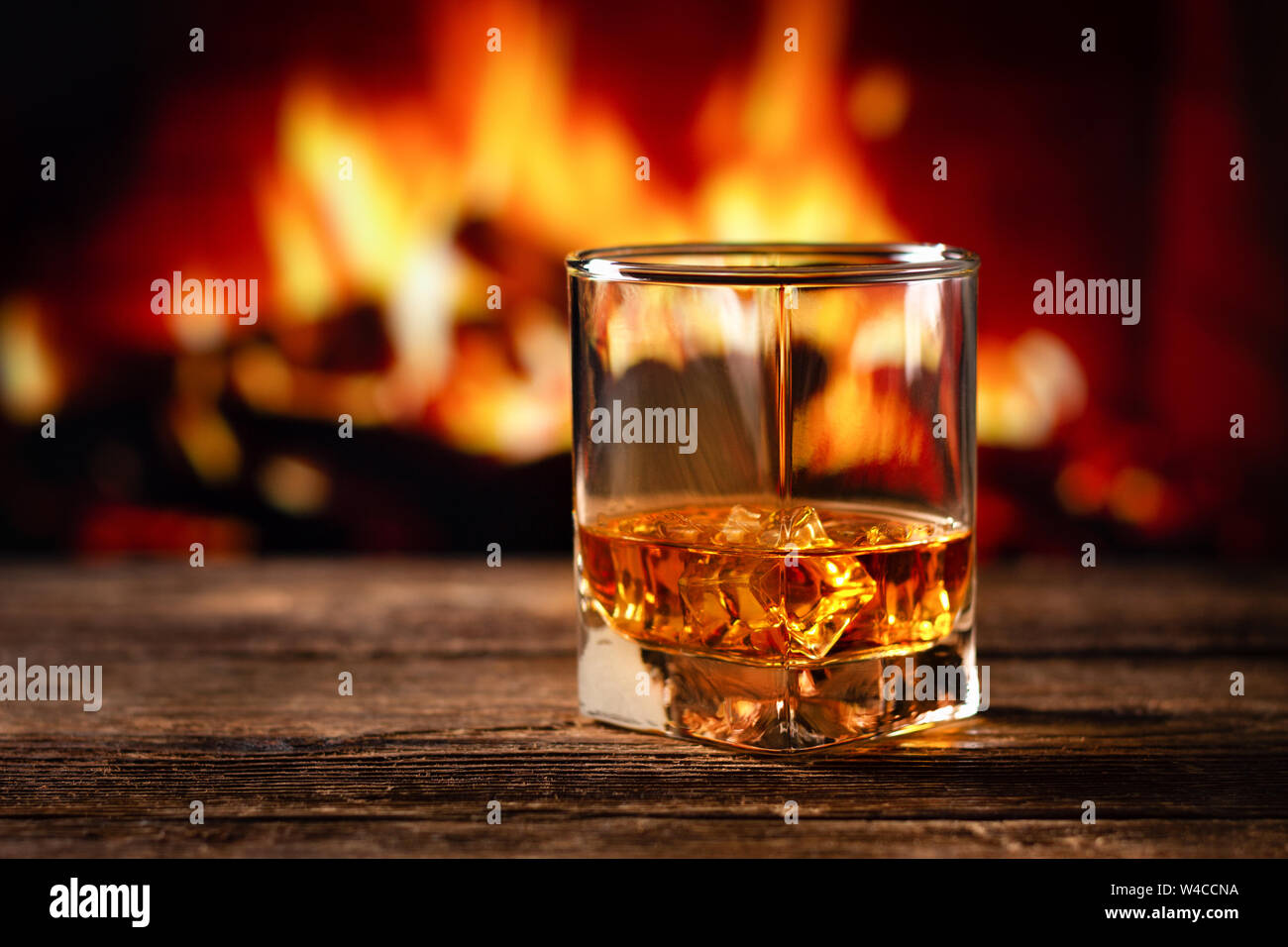 Whiskey in a glass with fire in the fireplace on the background Stock ...