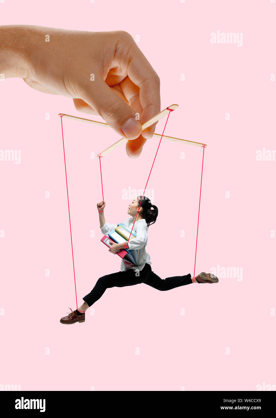 Woman like a puppet in somebodies hands on coral background. Concept of ...