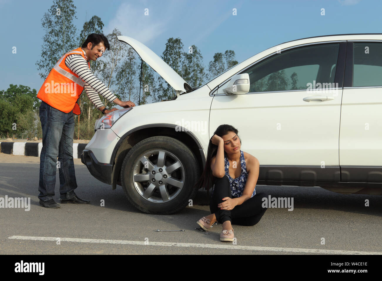 Mechanic repairing a woman car at the roadside Stock Photo - Alamy